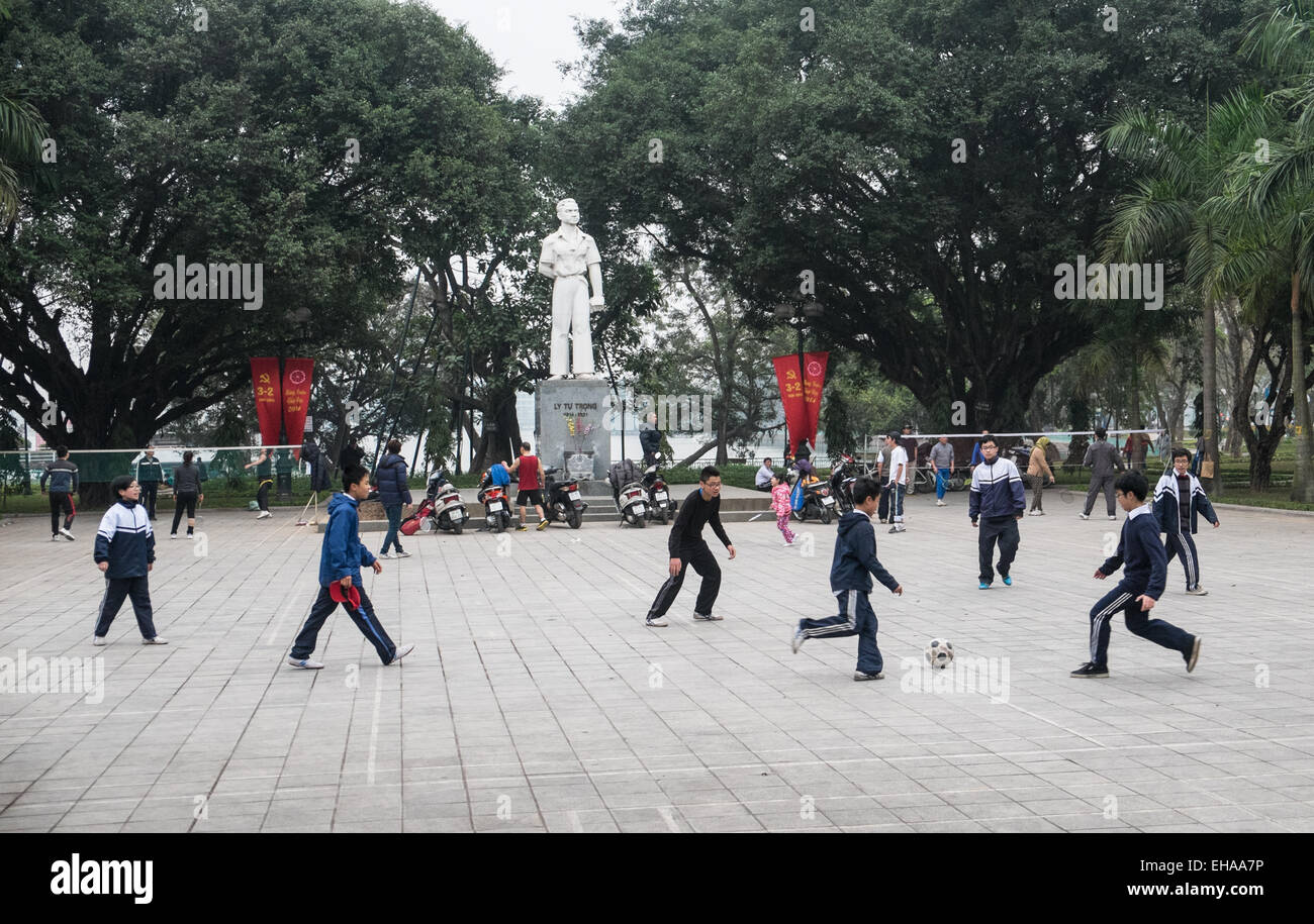 Boys playing football on concrete hard surface near west lake hi-res ...