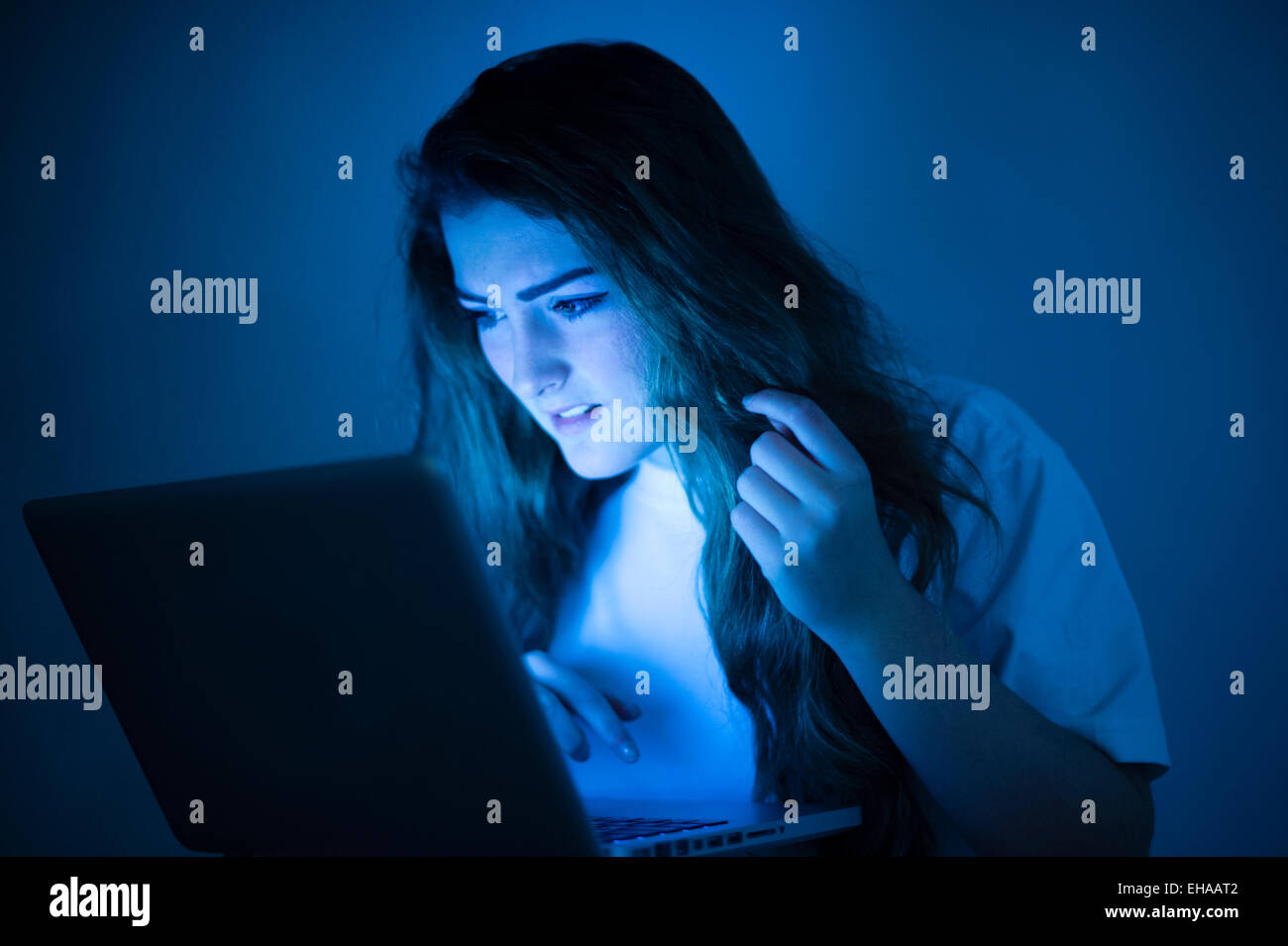 A worried 13 14 15 year old teenage girl on her laptop computer ...