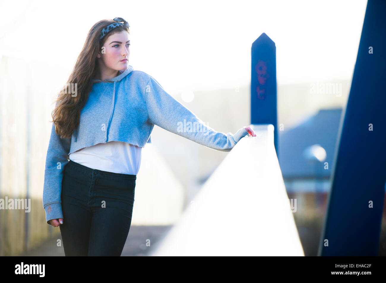 A sad lonely young 13 14 15 year old teenage girl outdoors outside ...