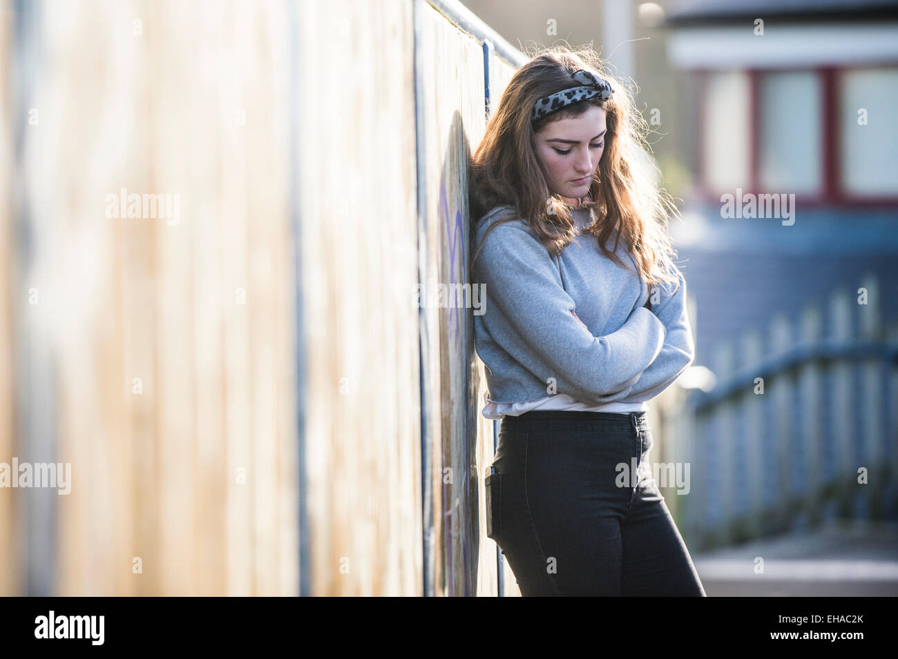 A sad lonely young 13 14 15 year old teenage girl outdoors outside ...