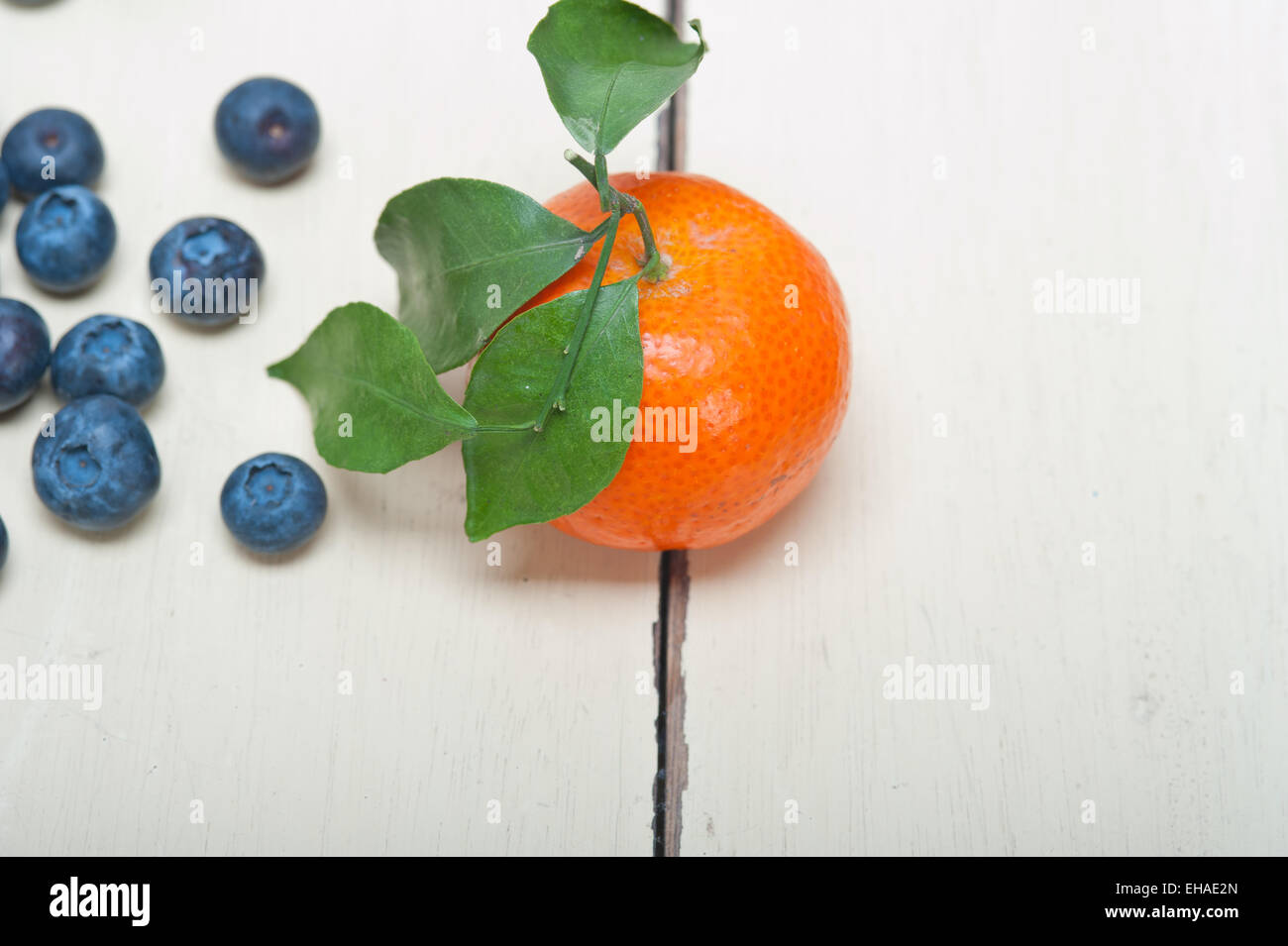 tangerine and blueberry on white rustic wood table Stock Photo - Alamy
