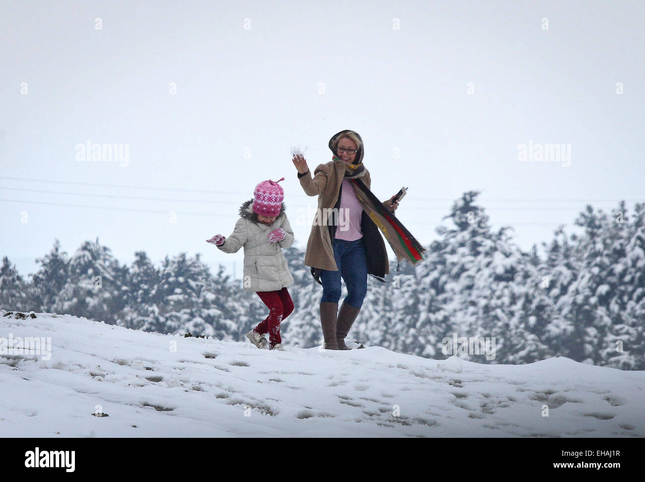 Tehran, Iran. 10th Mar, 2015. A woman and her daughter play with snow ...