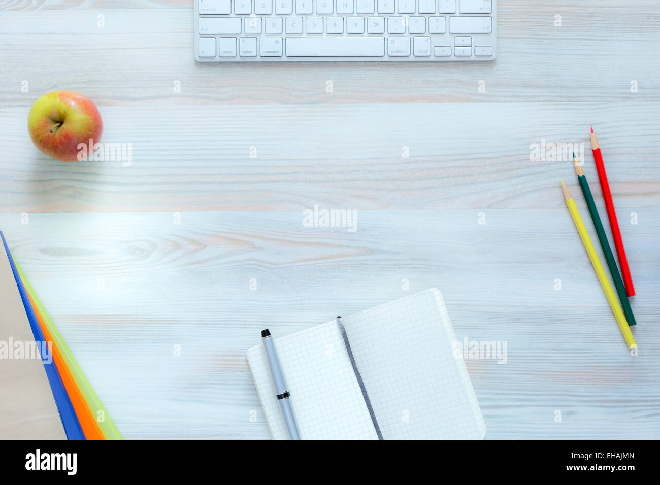 Top view of wooden desk with several color matching items: pencils ...