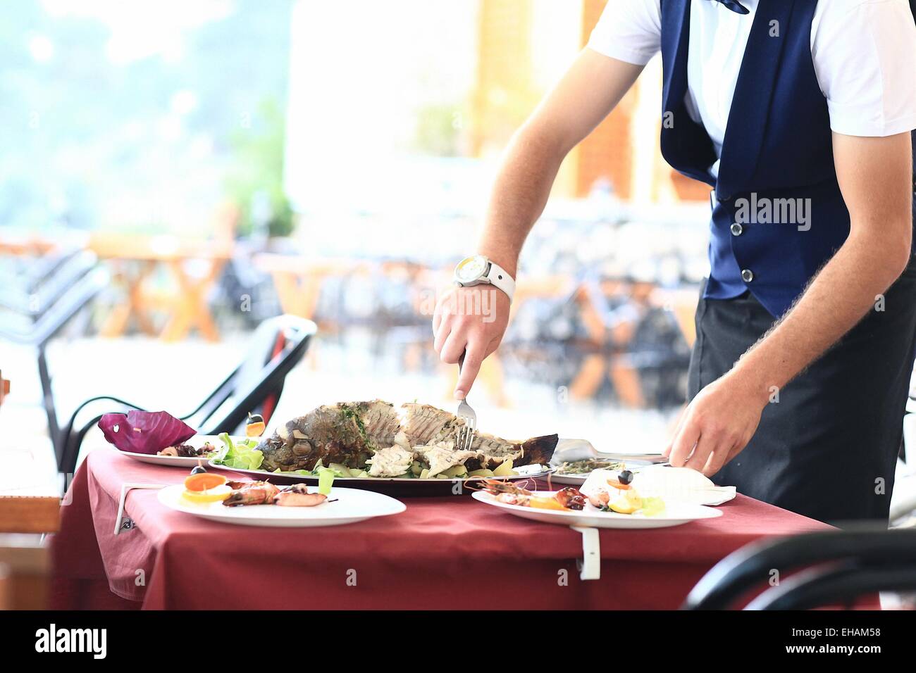 fish restaurant, fish is cut, the waiter hands Stock Photo - Alamy
