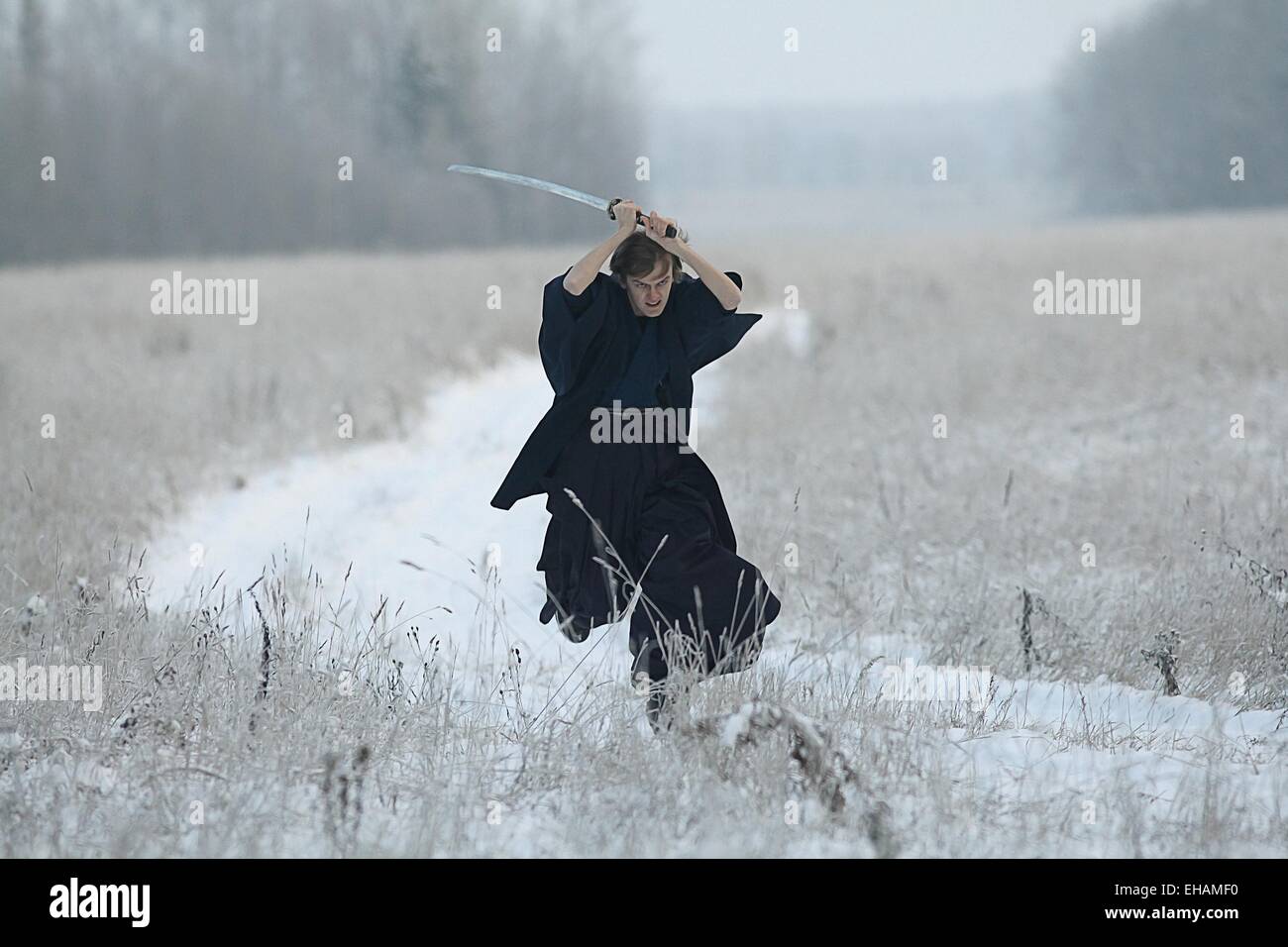running samurai wearing a kimono in a winter field dressed in black ...