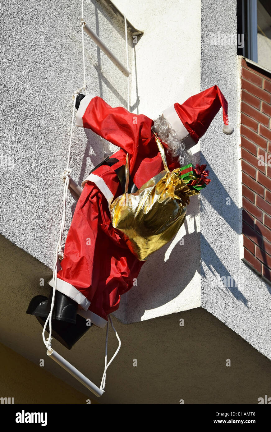 Santa Claus puppet is climbing up on the wall of a building Stock Photo ...