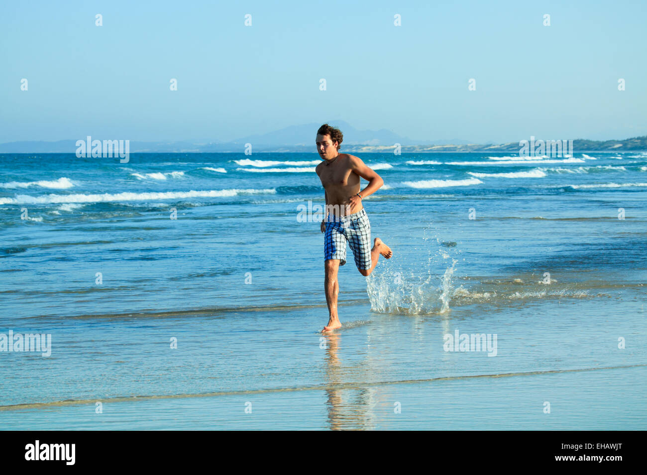 Young man running into waves hi-res stock photography and images - Alamy