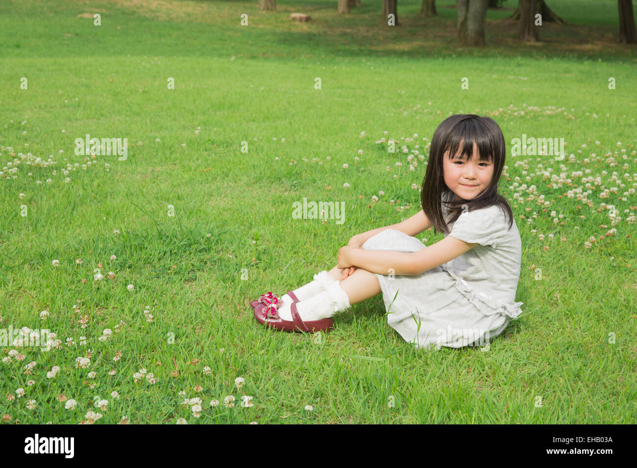 Japanese kid sitting on grass in a park Stock Photo - Alamy