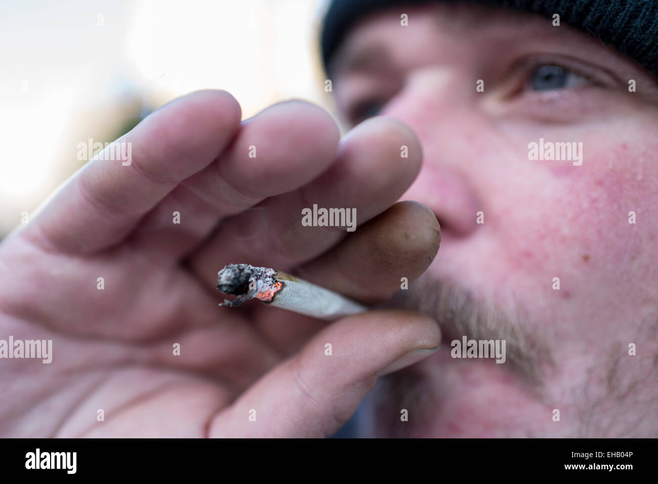A man smoking a joint using tobacco and Happy Joker, a Legal High Stock ...