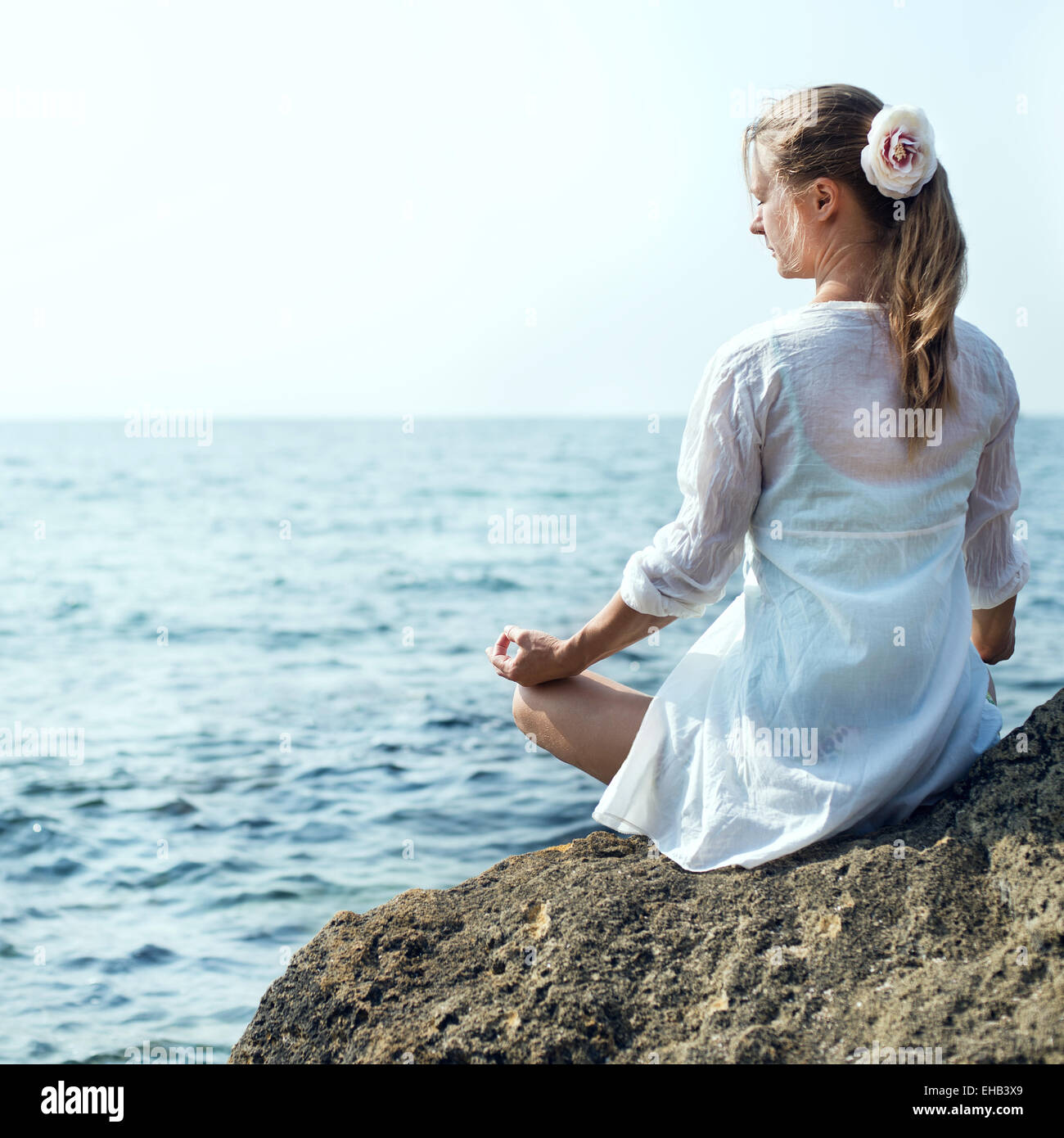 Woman meditating at the sea Stock Photo - Alamy