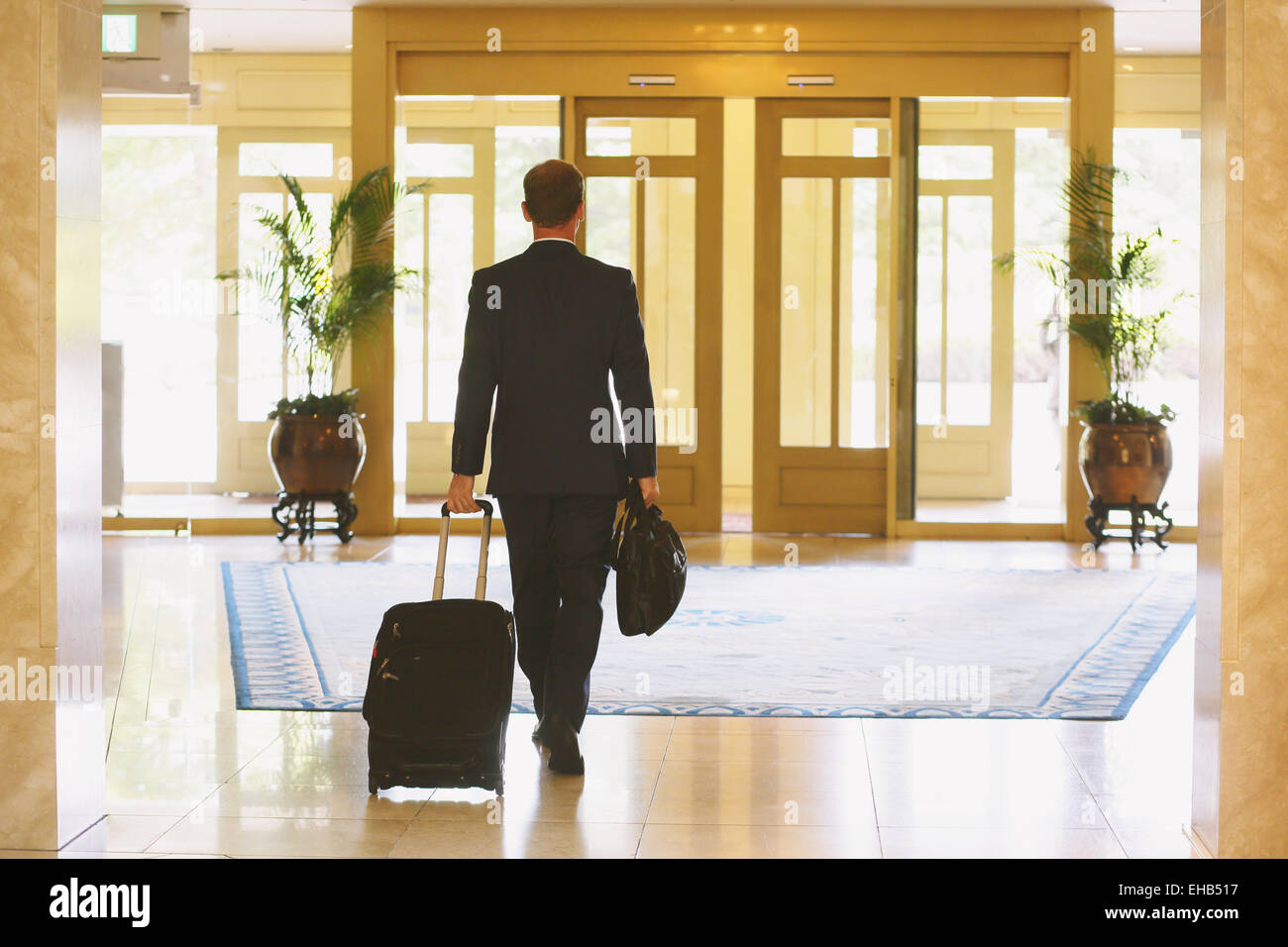 Businessman leaving hotel Stock Photo - Alamy