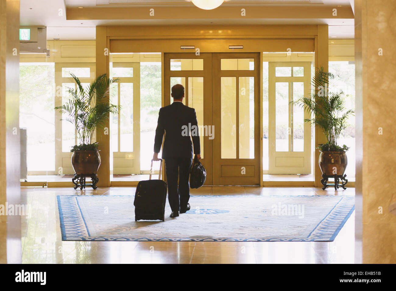 Businessman leaving hotel Stock Photo - Alamy