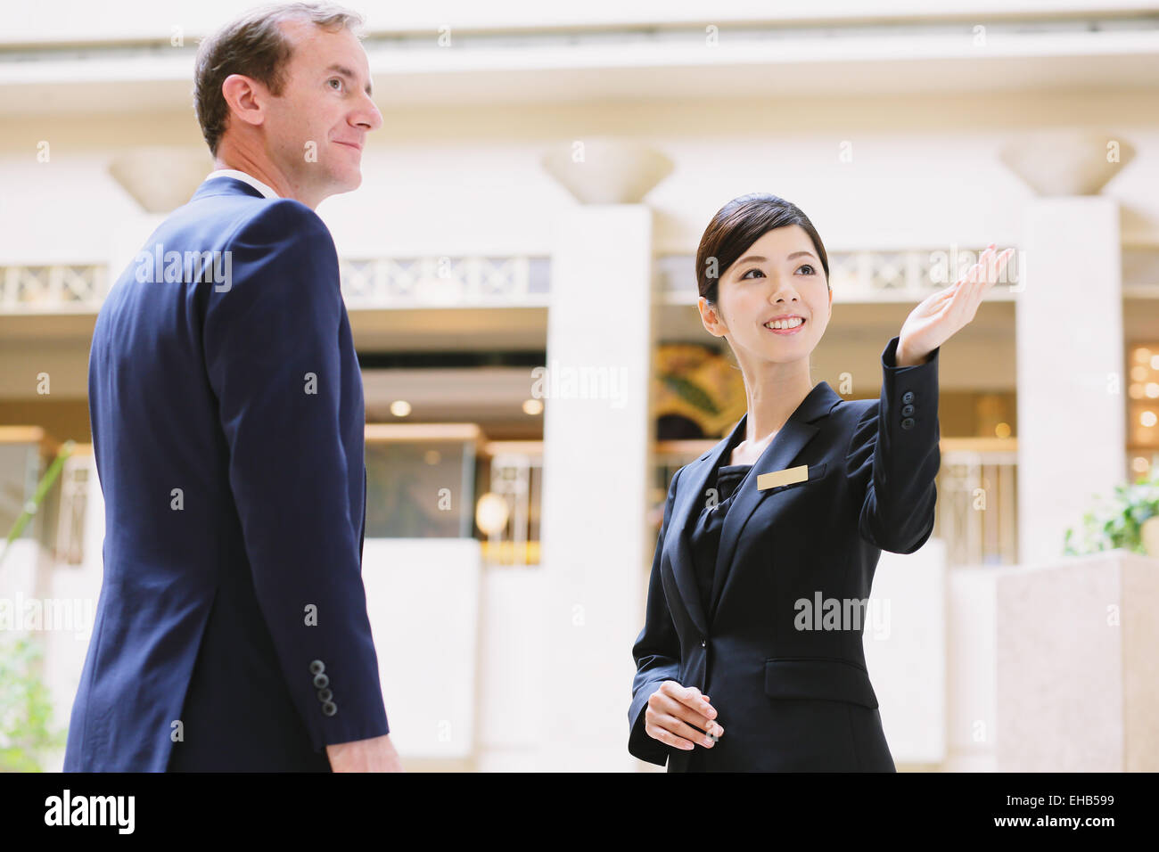 Japanese female hotel concierge dealing with a customer Stock Photo - Alamy