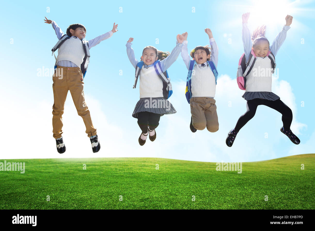 Elementary school students jumping on the grass Stock Photo - Alamy