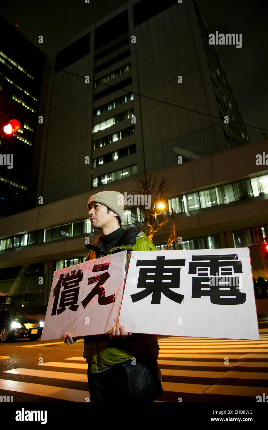 Tokyo, Japan. 11th Mar, 2015. Anti-nuclear demonstrator holds a placard ...