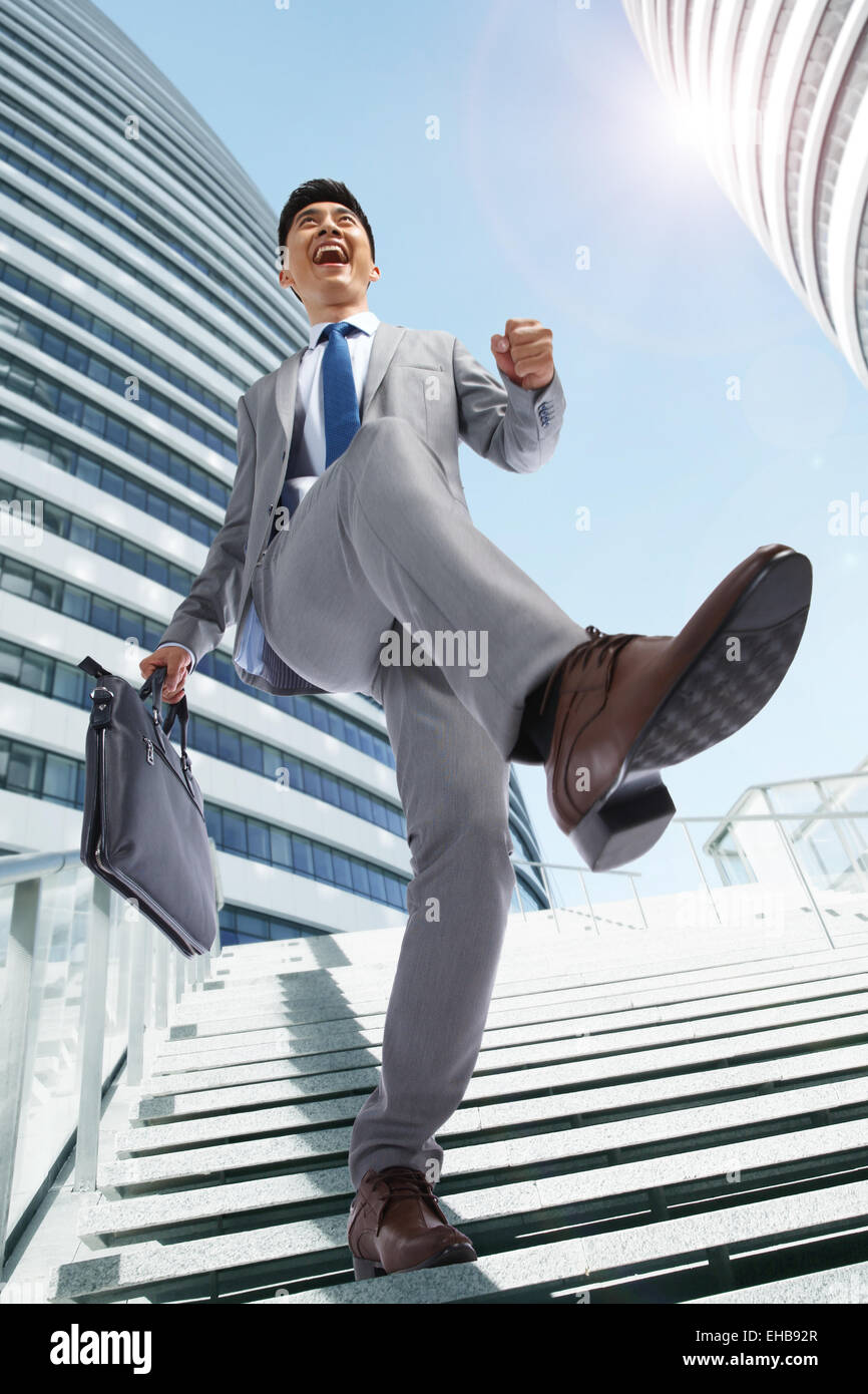 Eastern business man jump in the business district Stock Photo - Alamy