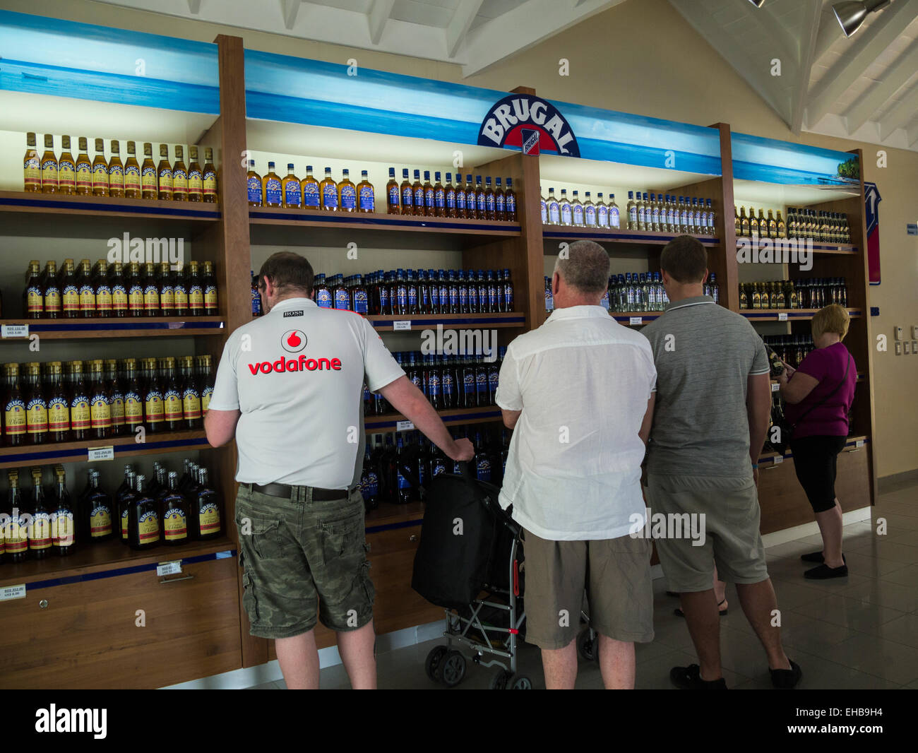 Tourists studying rum products in Brugal Rum Factory sampling room and ...