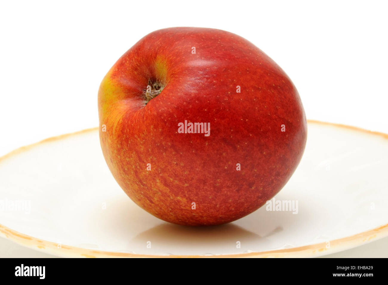 Red apple on a saucer with golden border Stock Photo - Alamy