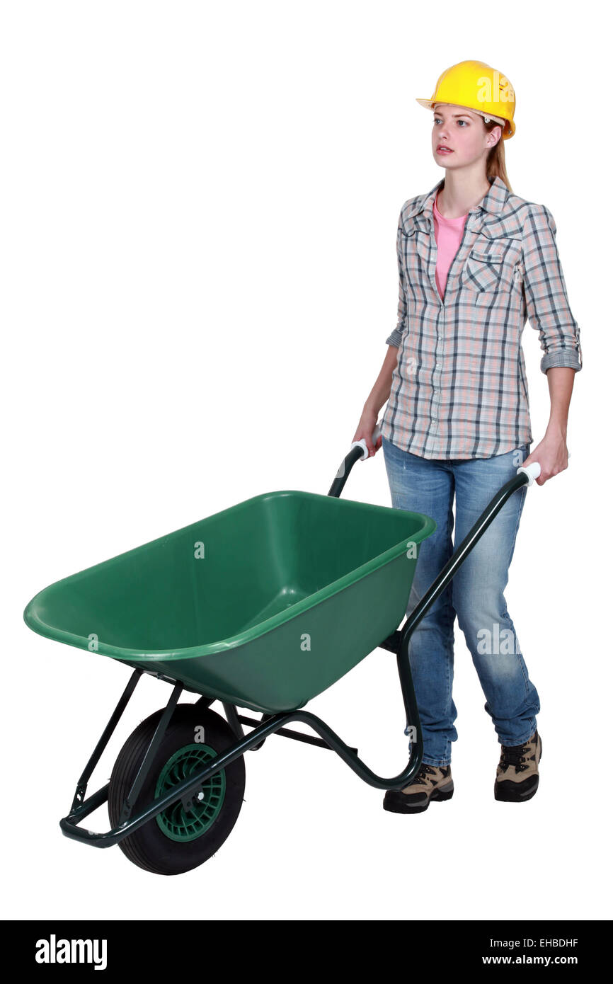 Woman wheeling wheelbarrow Stock Photo - Alamy