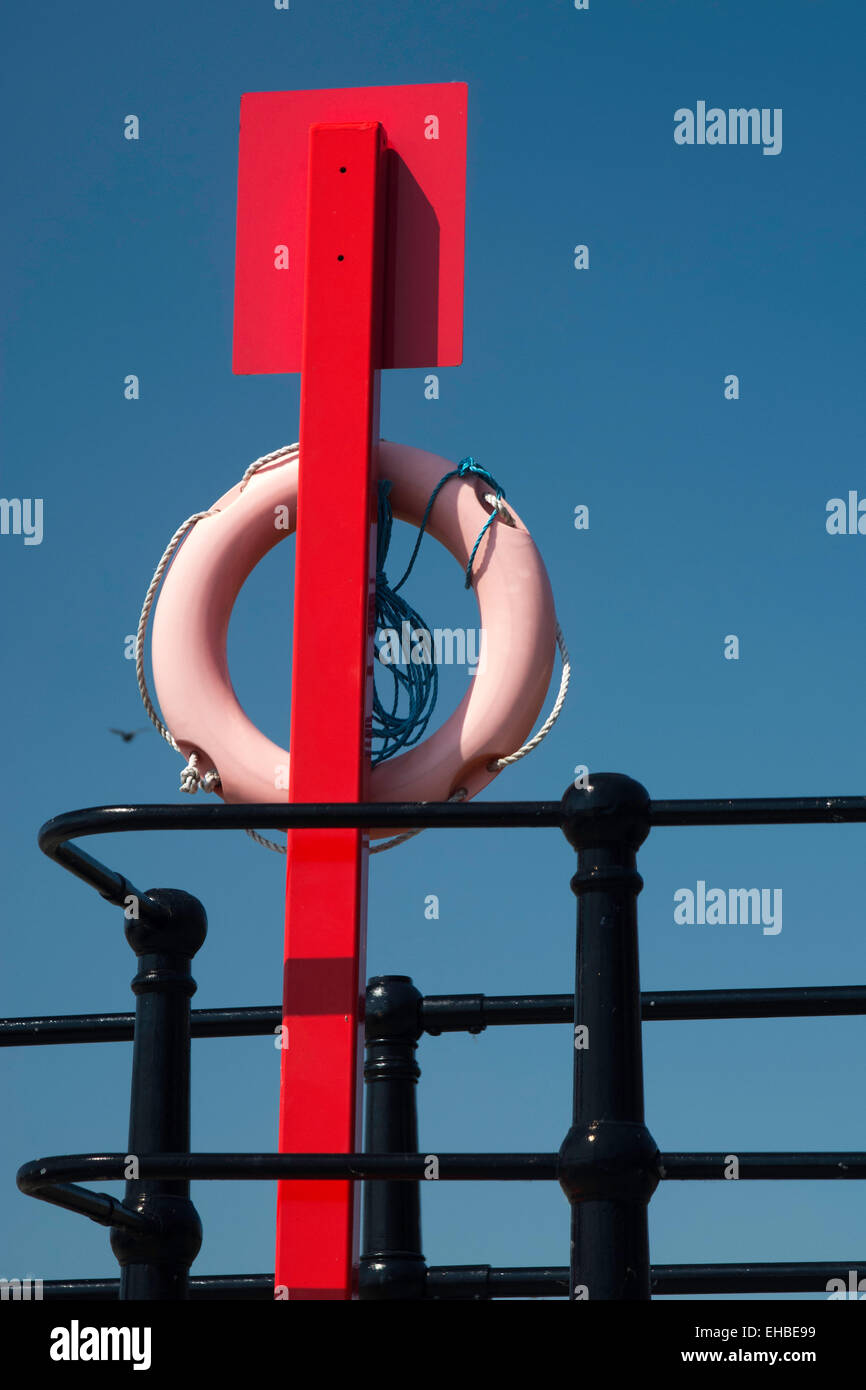 Back of a red warning sign with life ring against a clear blue sky ...