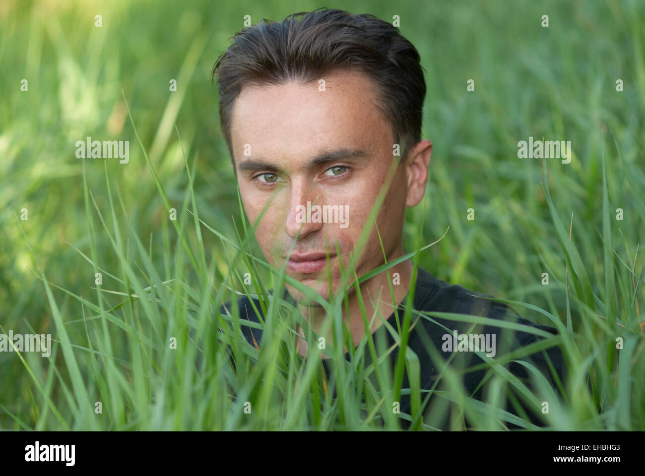 Man's portrait in the green grass background Stock Photo - Alamy
