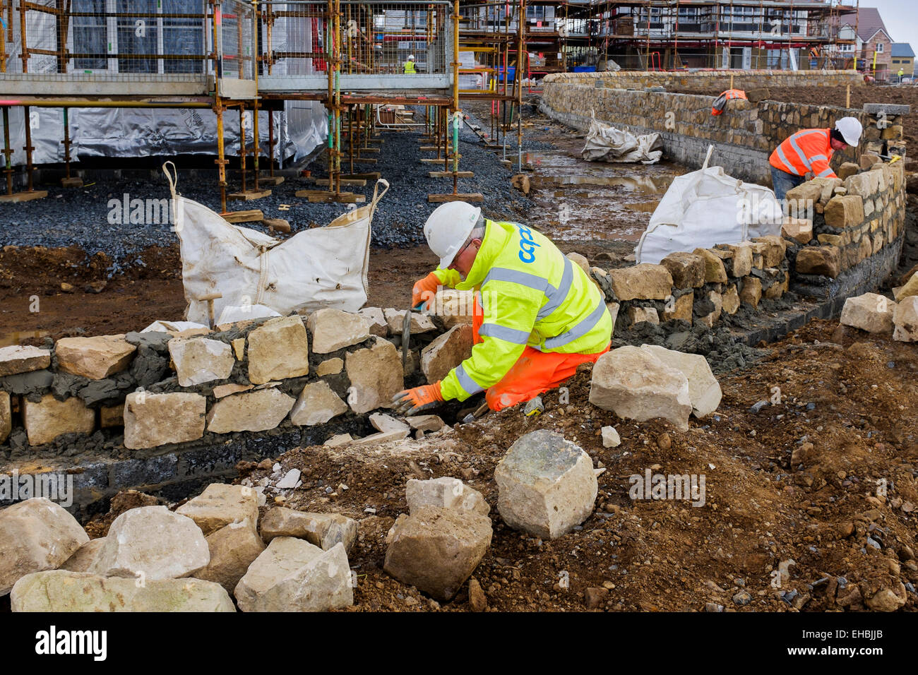 Master mason building a decorative perimeter wall of bloom sandstone on ...