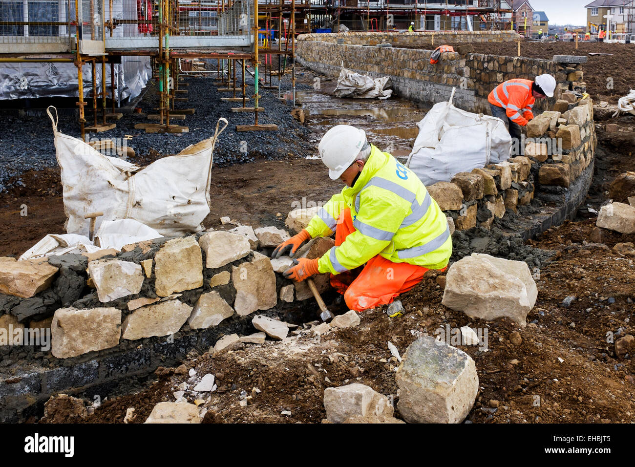 Master mason building a decorative perimeter wall of bloom sandstone on ...