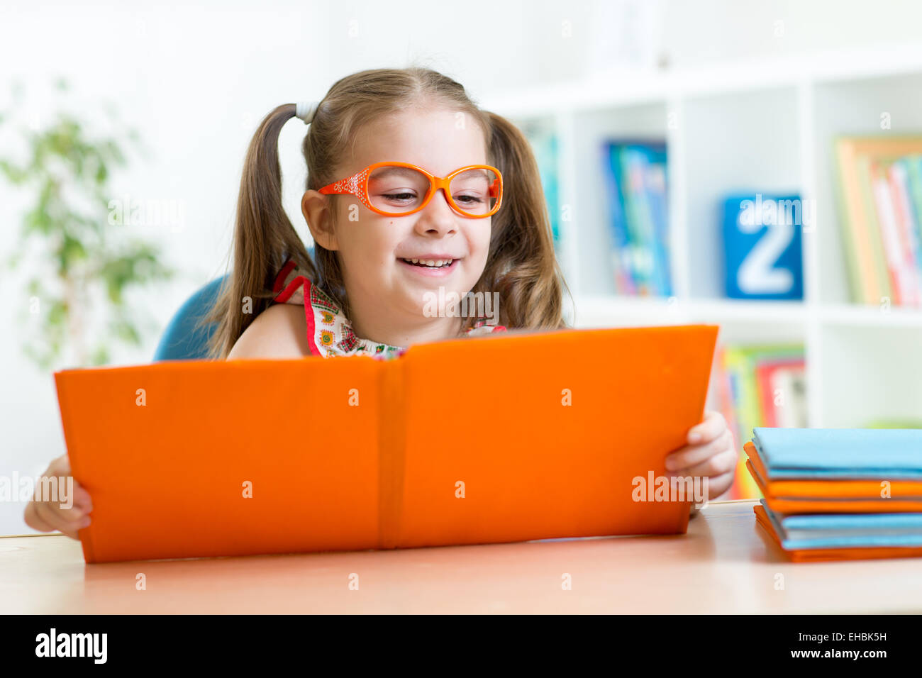 kid at the table with books Stock Photo - Alamy