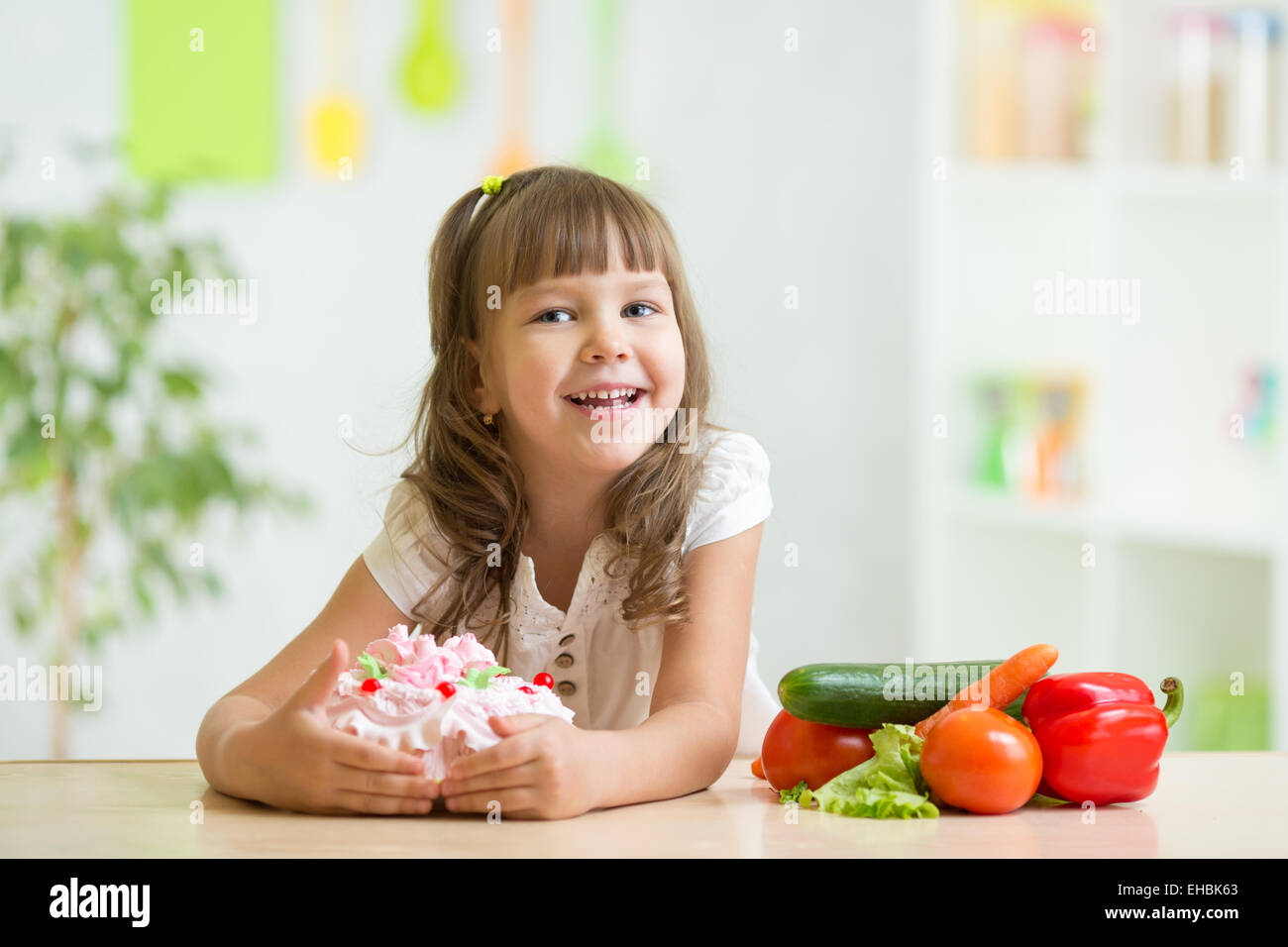 child choosing sweet cake instead of healthy vegetables Stock Photo - Alamy