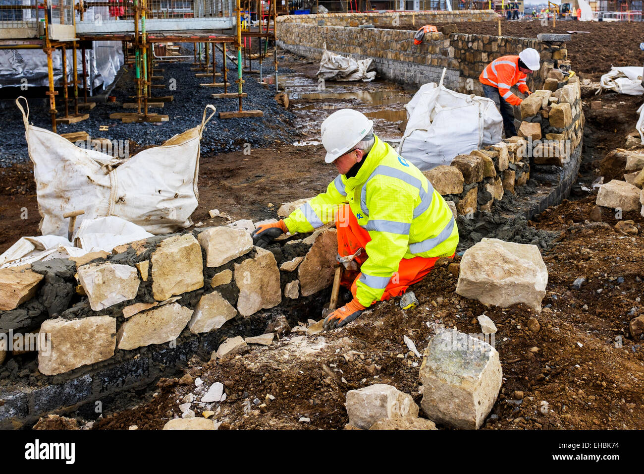 Master mason building a decorative perimeter wall of bloom sandstone on ...