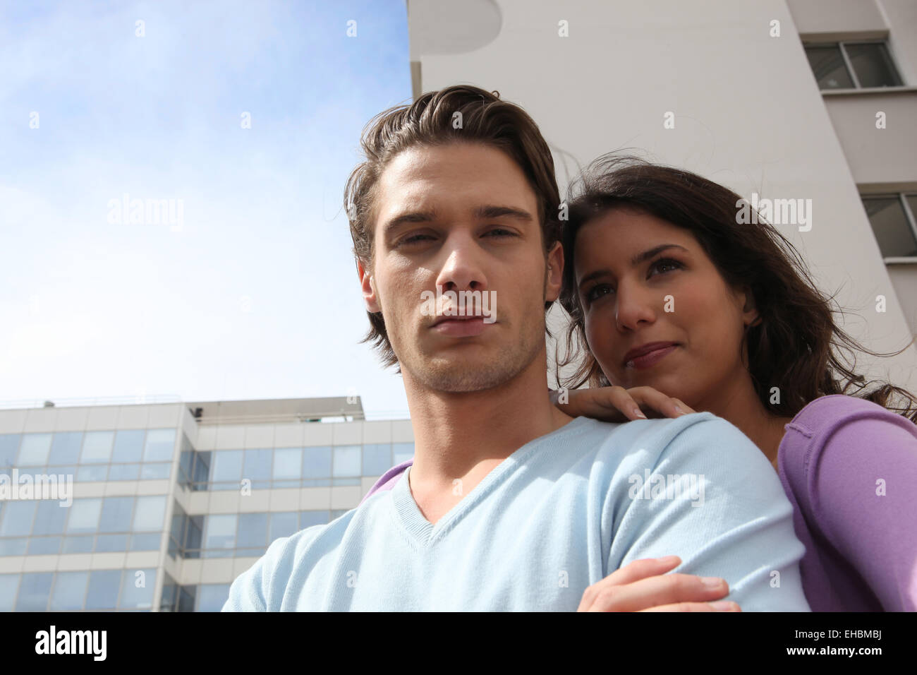 Couple standing in front of a building Stock Photo - Alamy