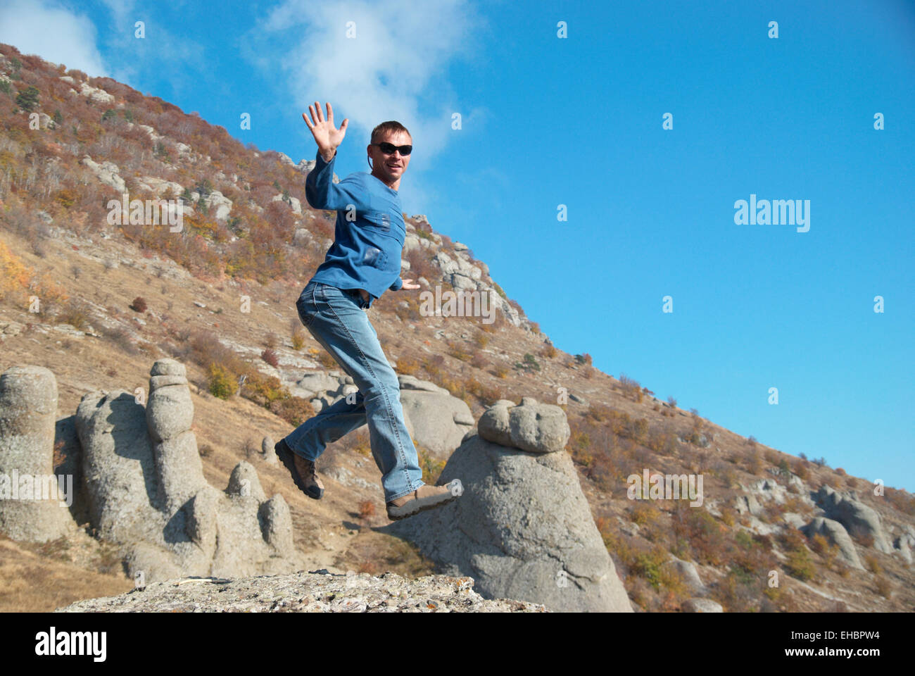 Man jumping on the rocks with landscape background Stock Photo - Alamy