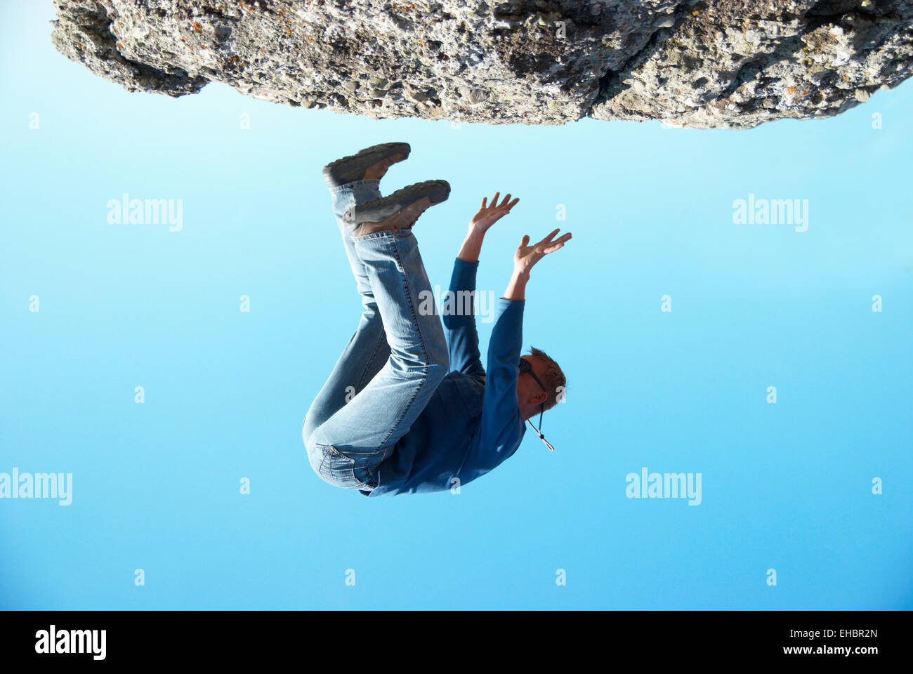 Falling down man from the rock with blue background Stock Photo - Alamy