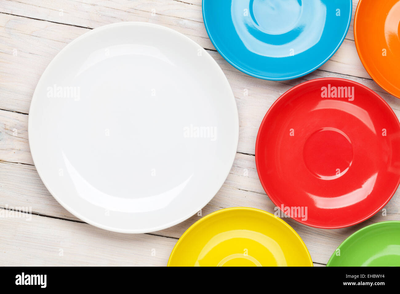 Colorful plates over white wooden table background with copy space ...