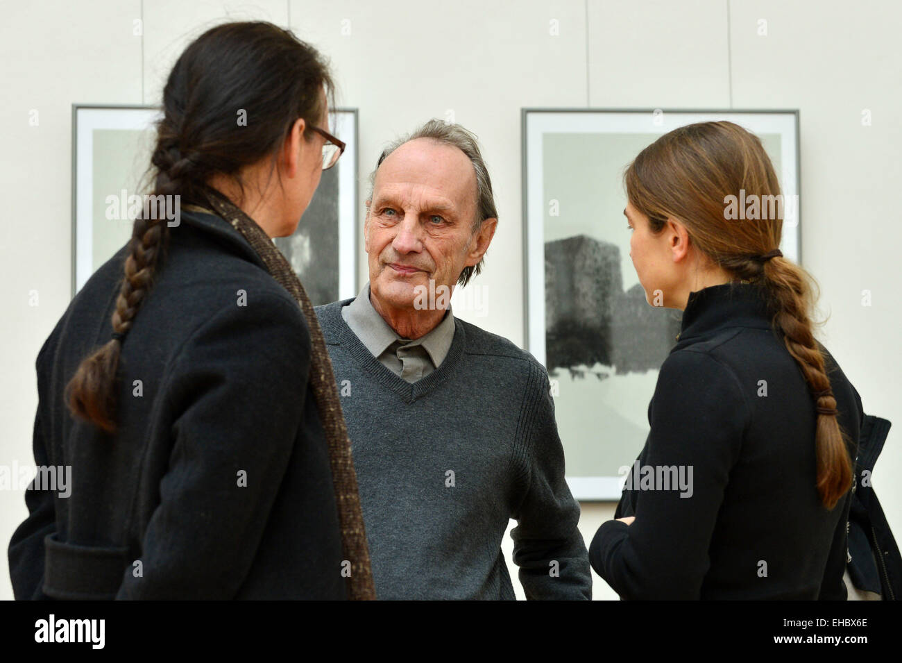 Artist Klaus Bose (C) talks to visitors at the exhibition venue ...