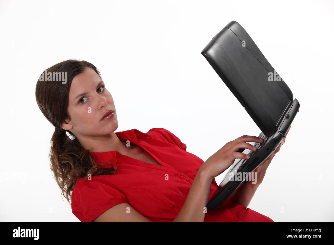 Stern businesswoman holding laptop Stock Photo - Alamy