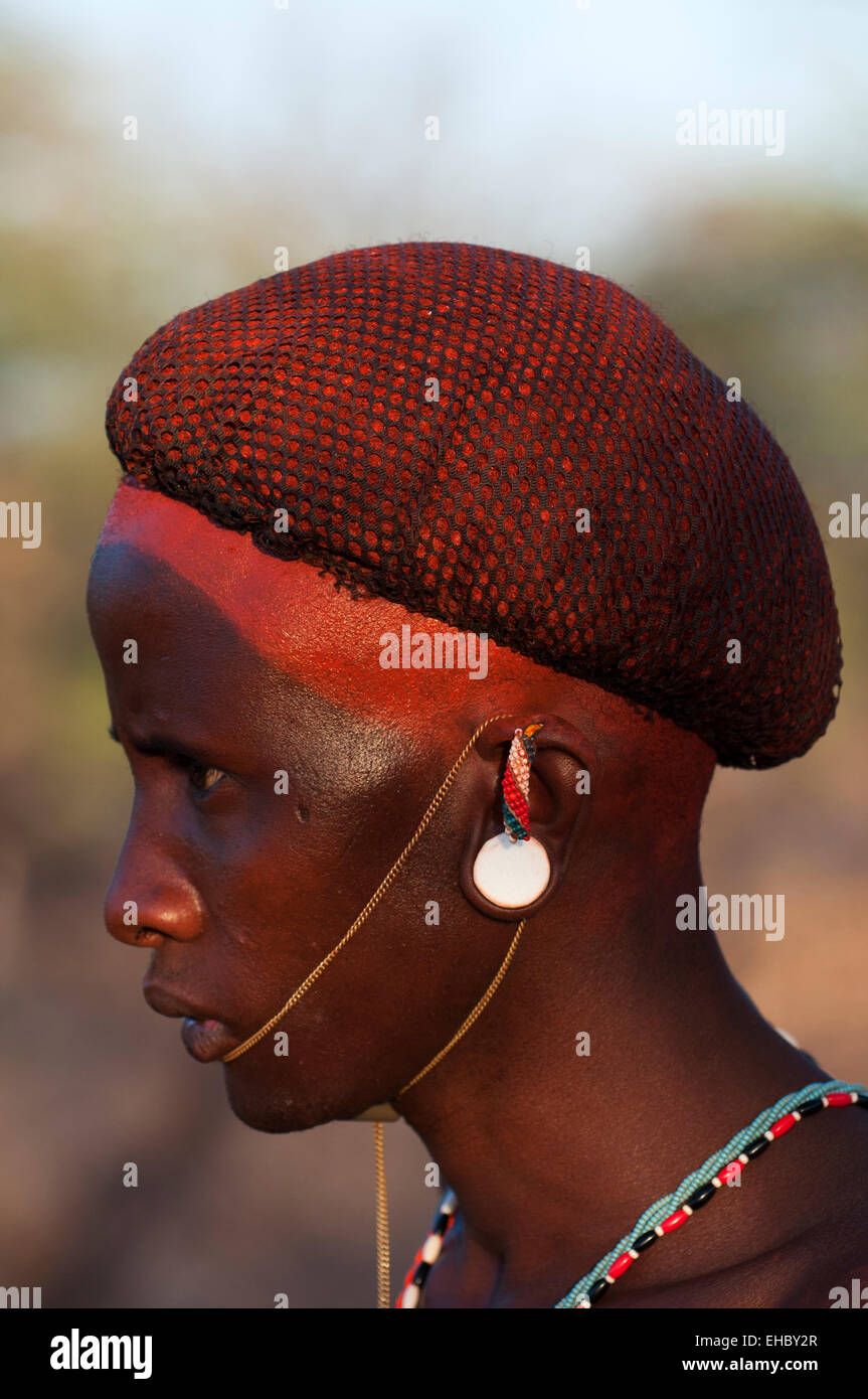 A Samburu Moran (warrior) with hair protected by a net and red ochre ...