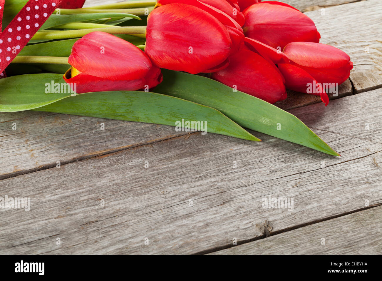 Fresh red tulips bouquet over wooden table background with copy space ...