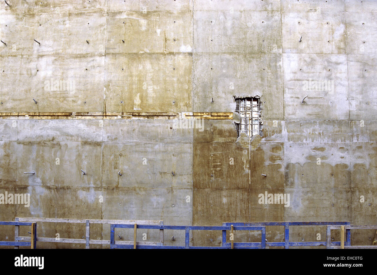 Concrete wall on a constructio site with blue fence Stock Photo - Alamy