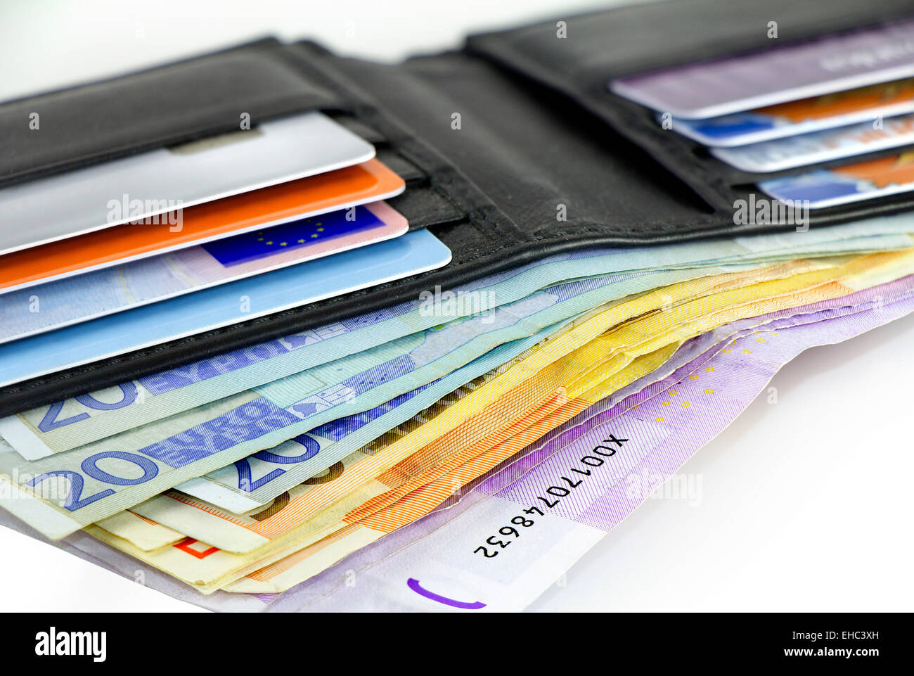 A bundle of Euro banknotes and credit cards in a black leather wallet ...