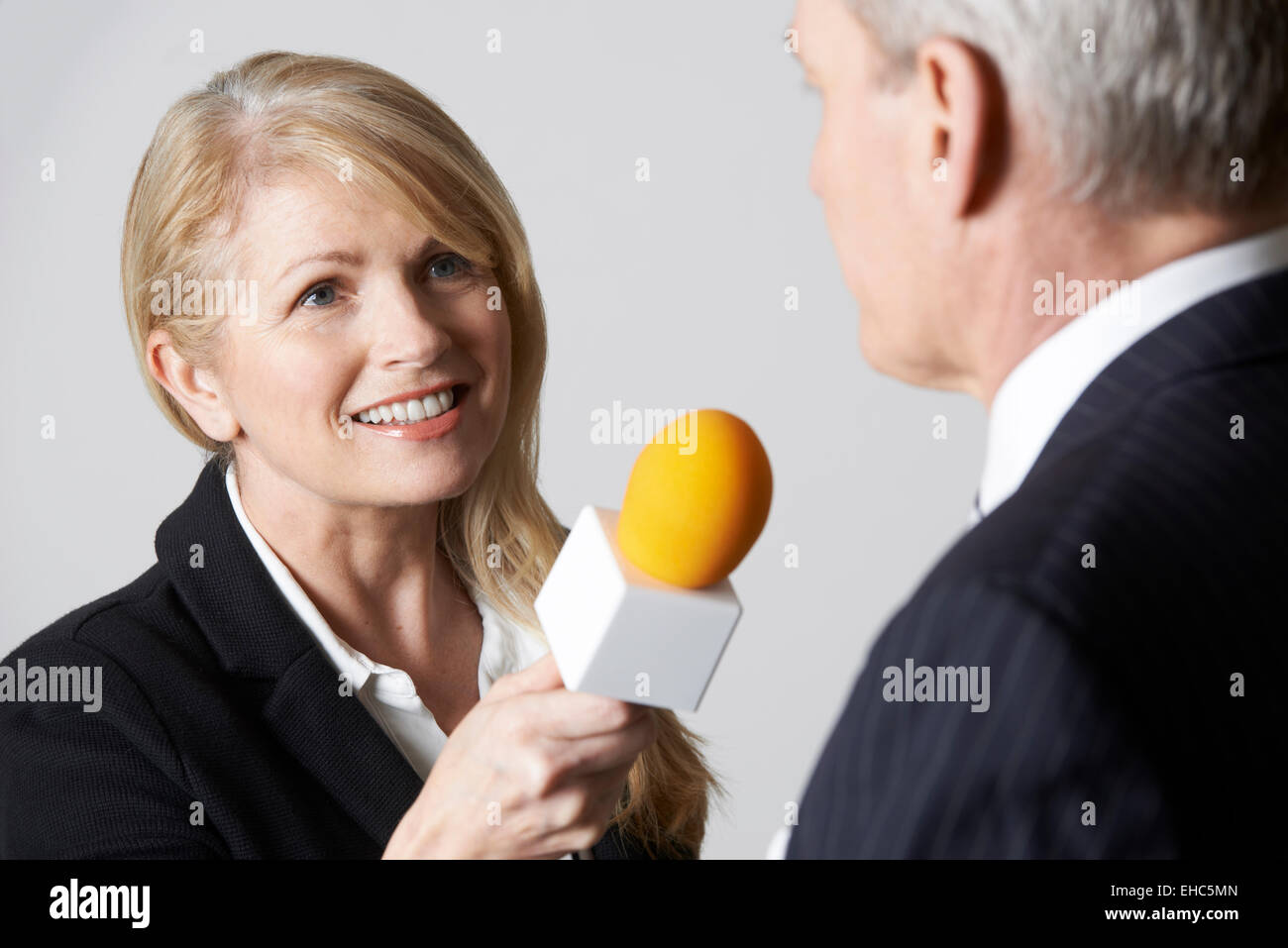 Female Journalist With Microphone Interviewing Businessman Stock Photo ...