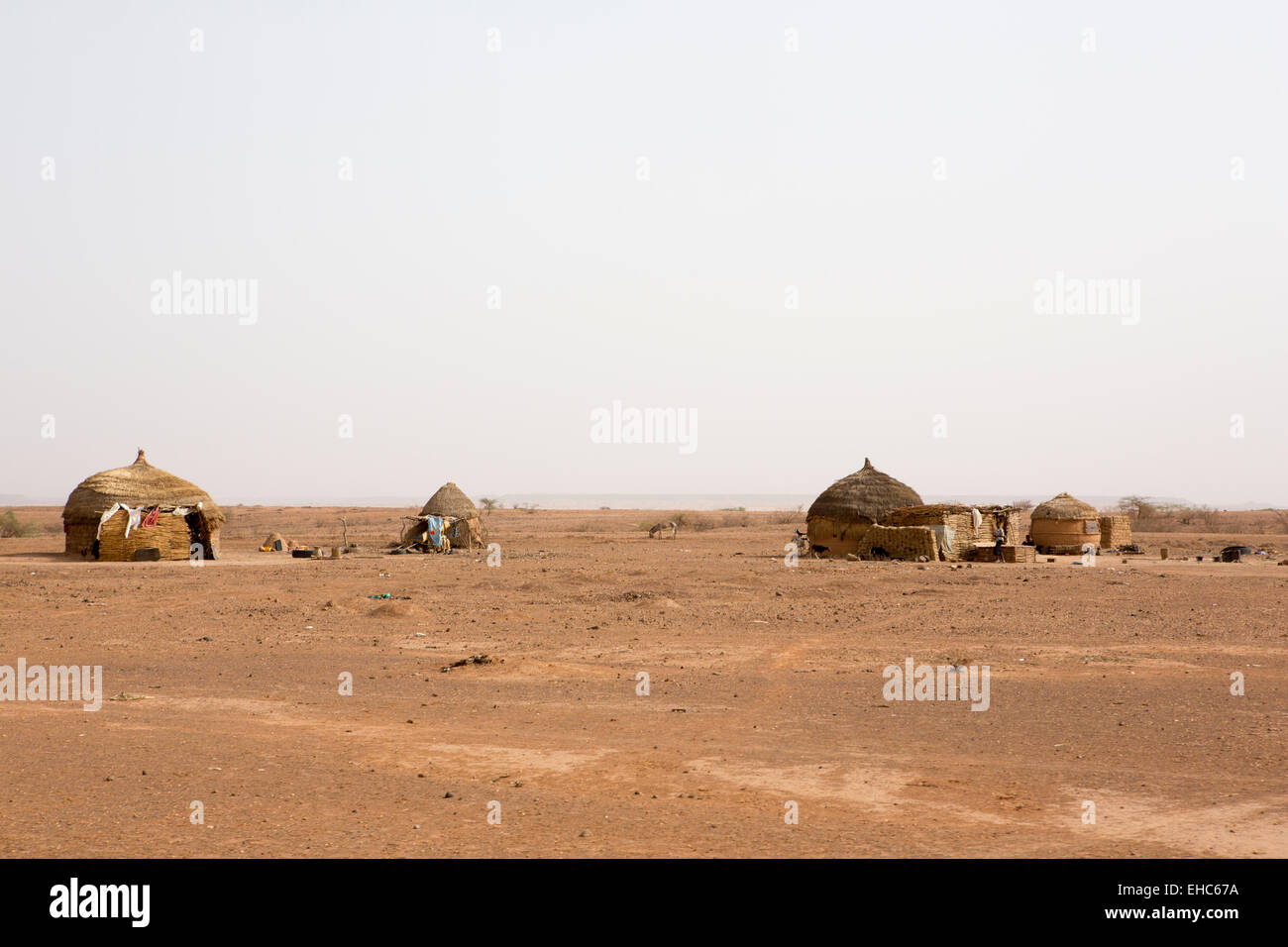 Tera, Niger, May 2012: Men walk through a small village in the mid-day ...