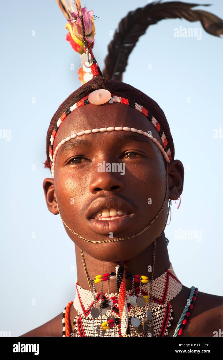 A Samburu Moran (warrior) wirh beaded necklaces and feathered headdress ...