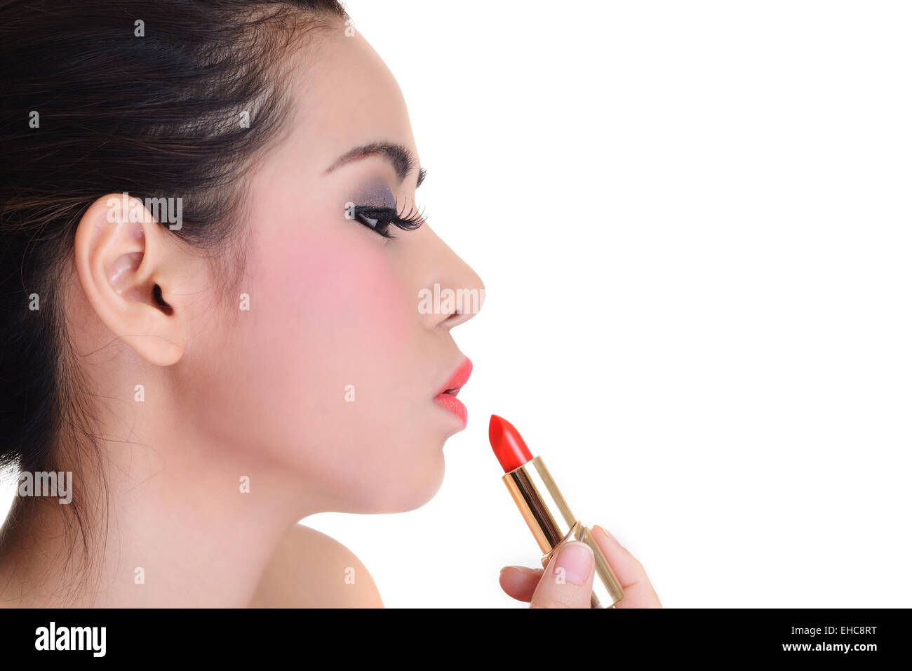 Side head shot of pretty girl with red lipstick in her hand on white ...