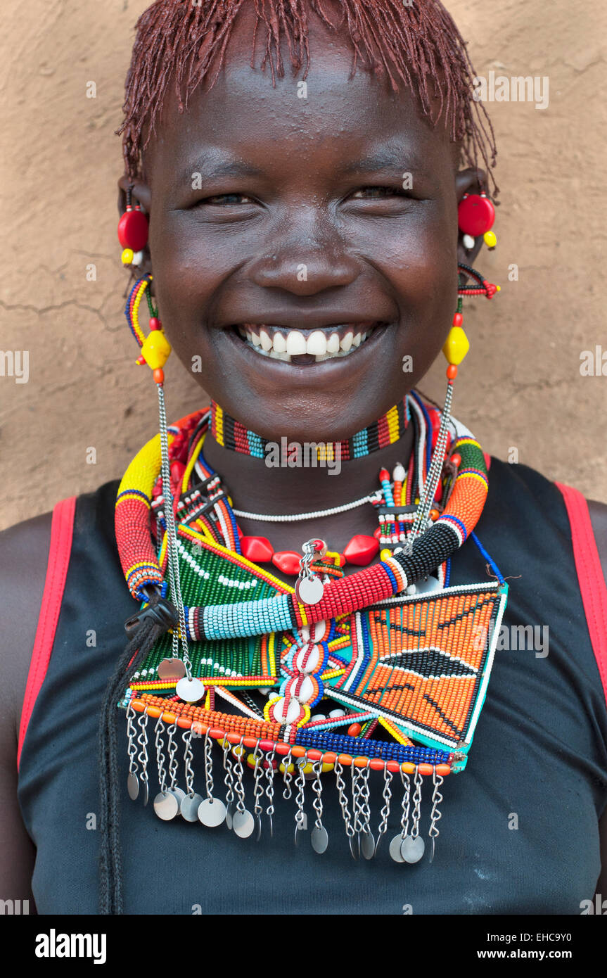 A smiling Pokot girl with colorful beaded necklaces and earrings ...