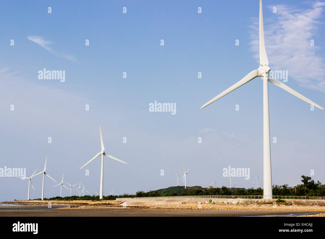 Wind turbines at seaside against blue sky Stock Photo - Alamy