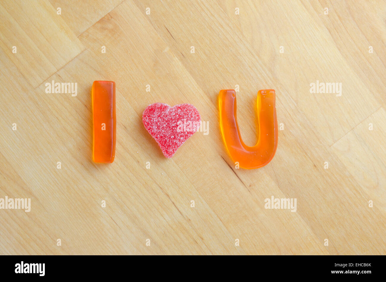 Orange letters and a red gummy heart display the message I love You ...