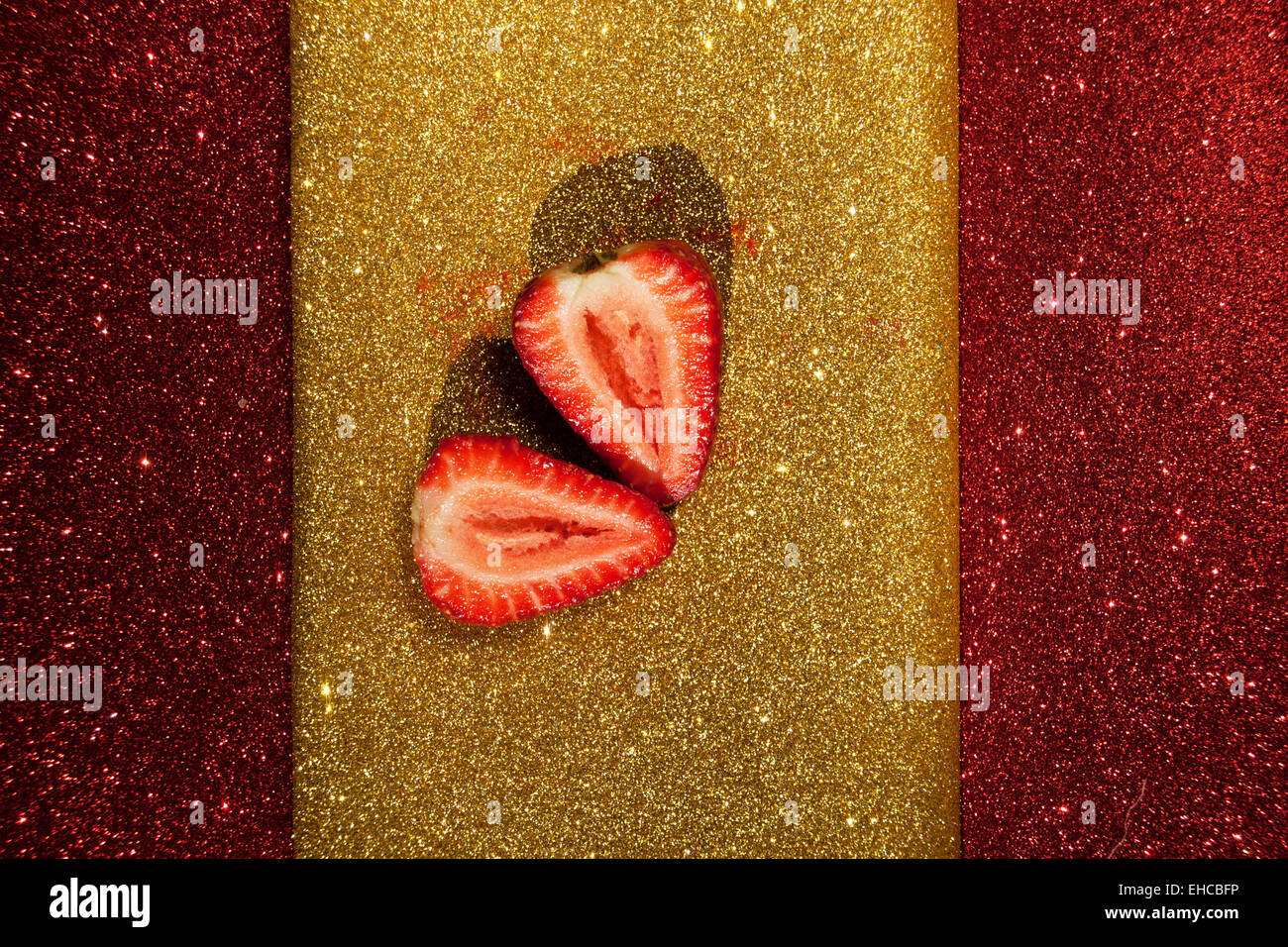 Two slices of a strawberry, gold and red, a very glittery image Stock ...