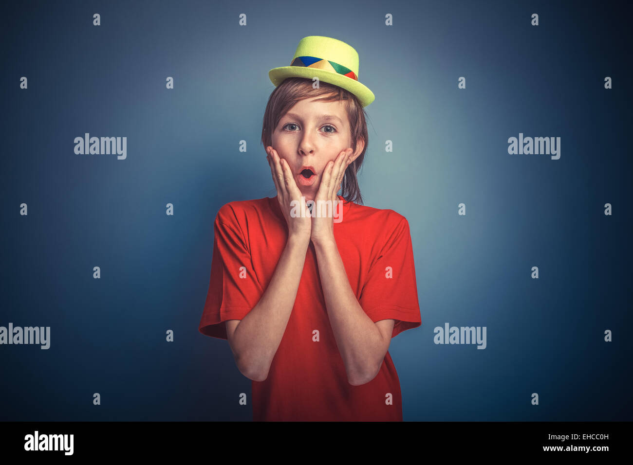 European -looking boy of twelve years in the hat on a gray bac Stock ...