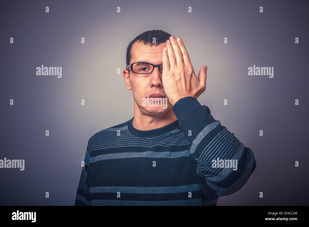 male of European appearance brunet in sweater covered half of hi Stock ...